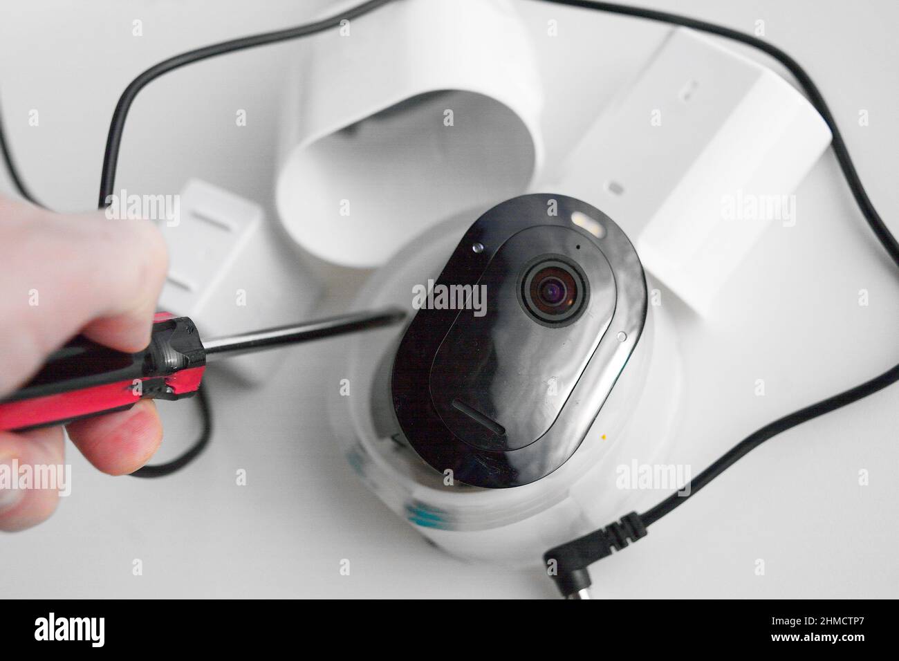 a hand with screwdriver fixing a disassembled surveillance camera Stock ...