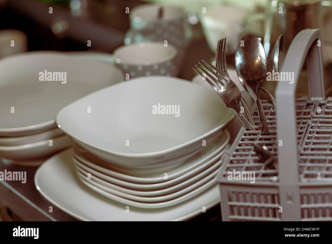 sorting clean dishes after wash, indoor filtered image Stock Photo - Alamy