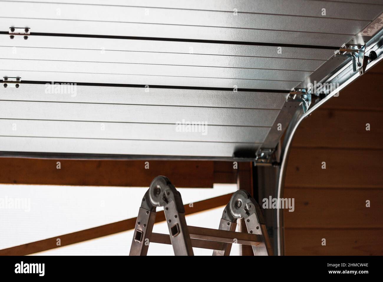 aluminium expandable ladder next to a rolling shutter garage door ...