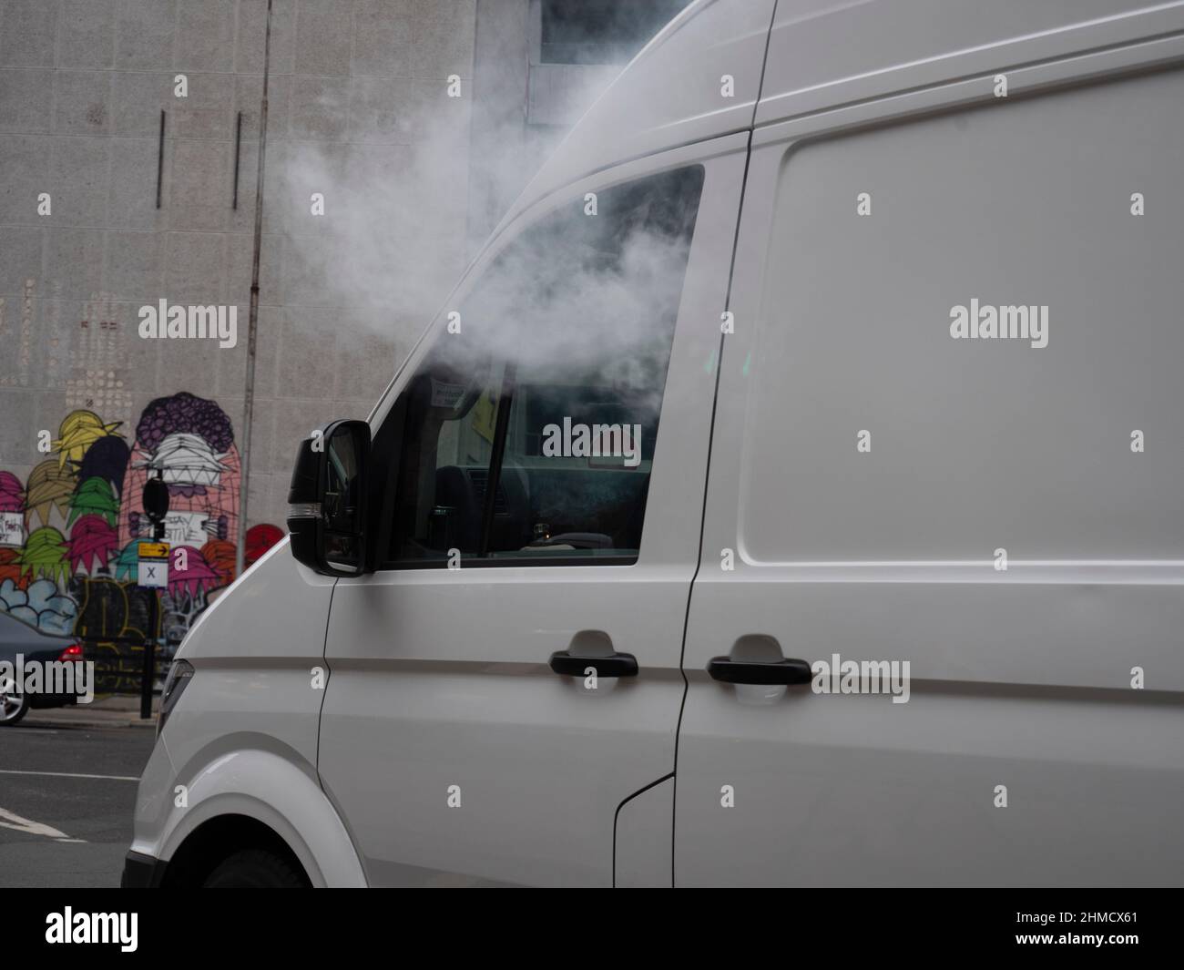 man smoking vaping in white van with smoke billowing from window Stock ...