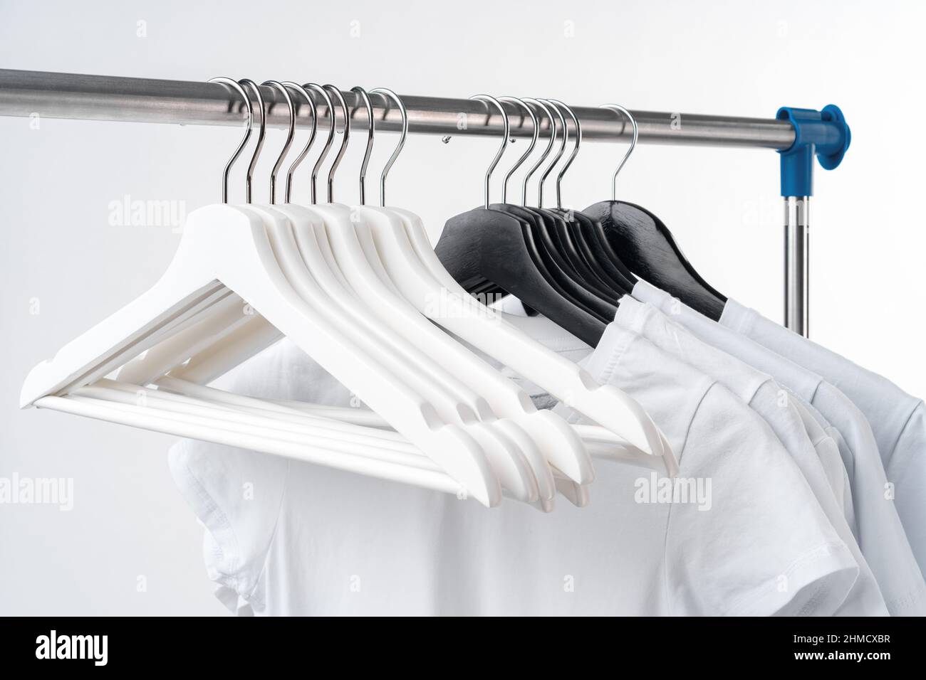 Clothes hang on clothing rack over white background Stock Photo - Alamy
