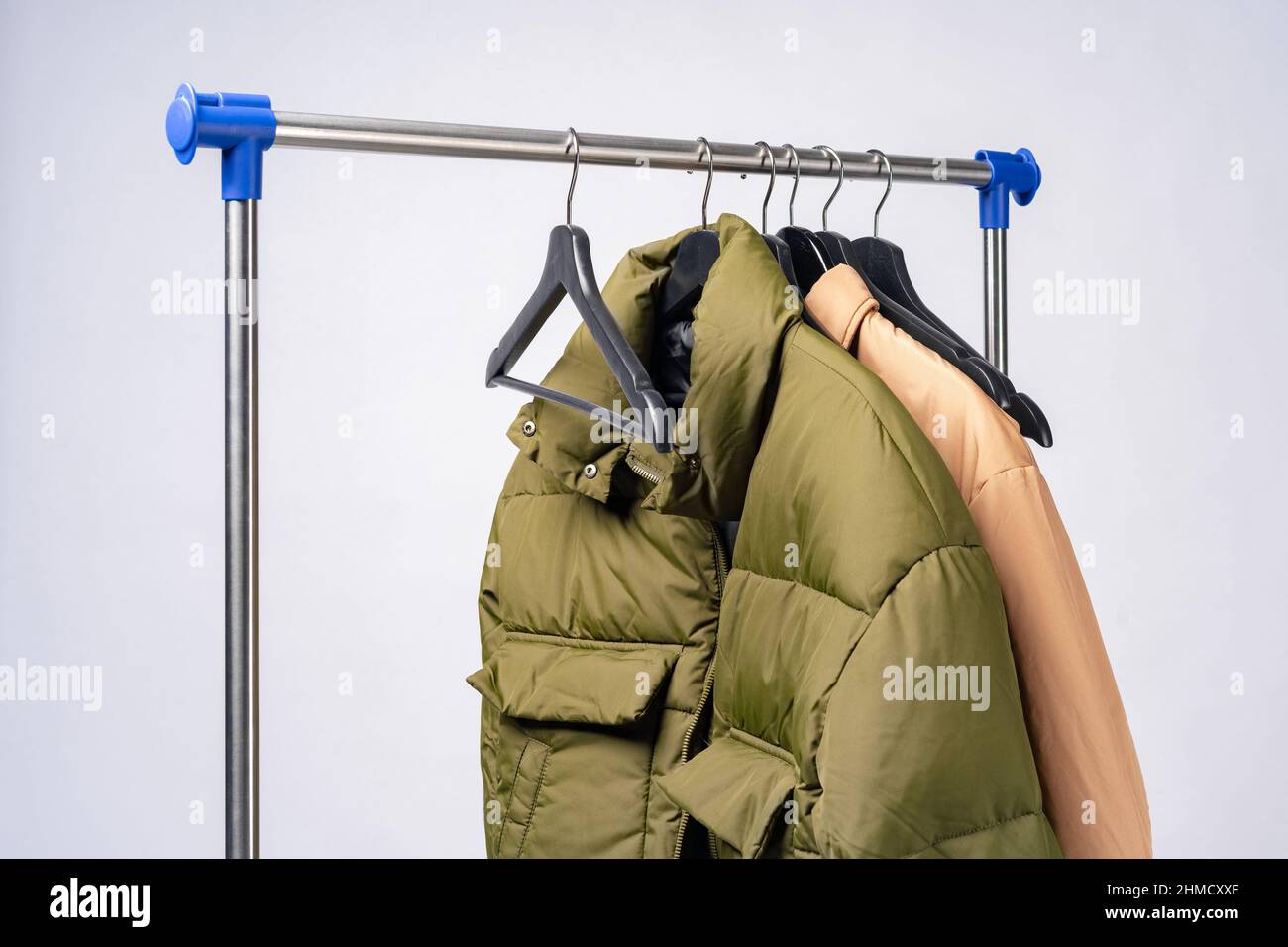 Clothes hang on clothing rack over white background Stock Photo - Alamy