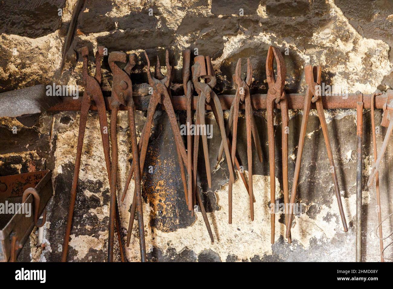 Old forging tools hanging on a wall Stock Photo - Alamy