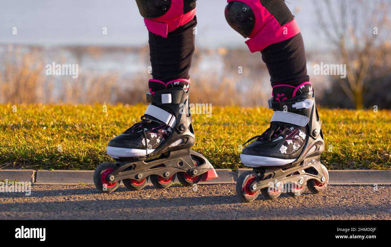 Teenage girl is skating on roller blades in the park. Copy Space Stock ...