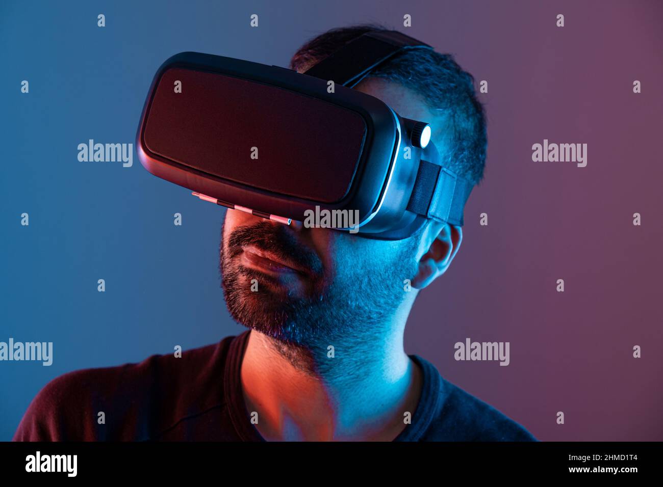 Young man in VR glasses close up portrait virtual reality in color neon ...
