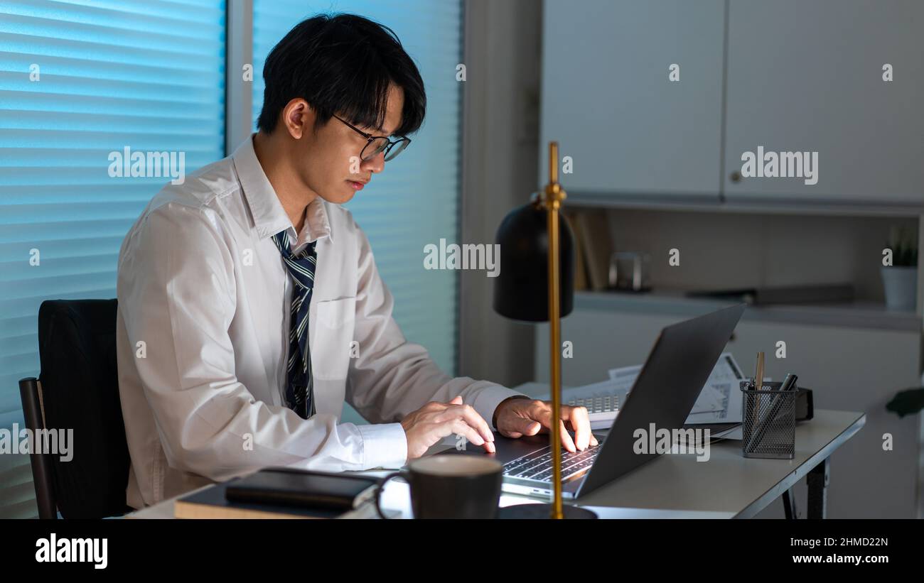 Overwork Concept The man sitting at his desk and focusing on working ...