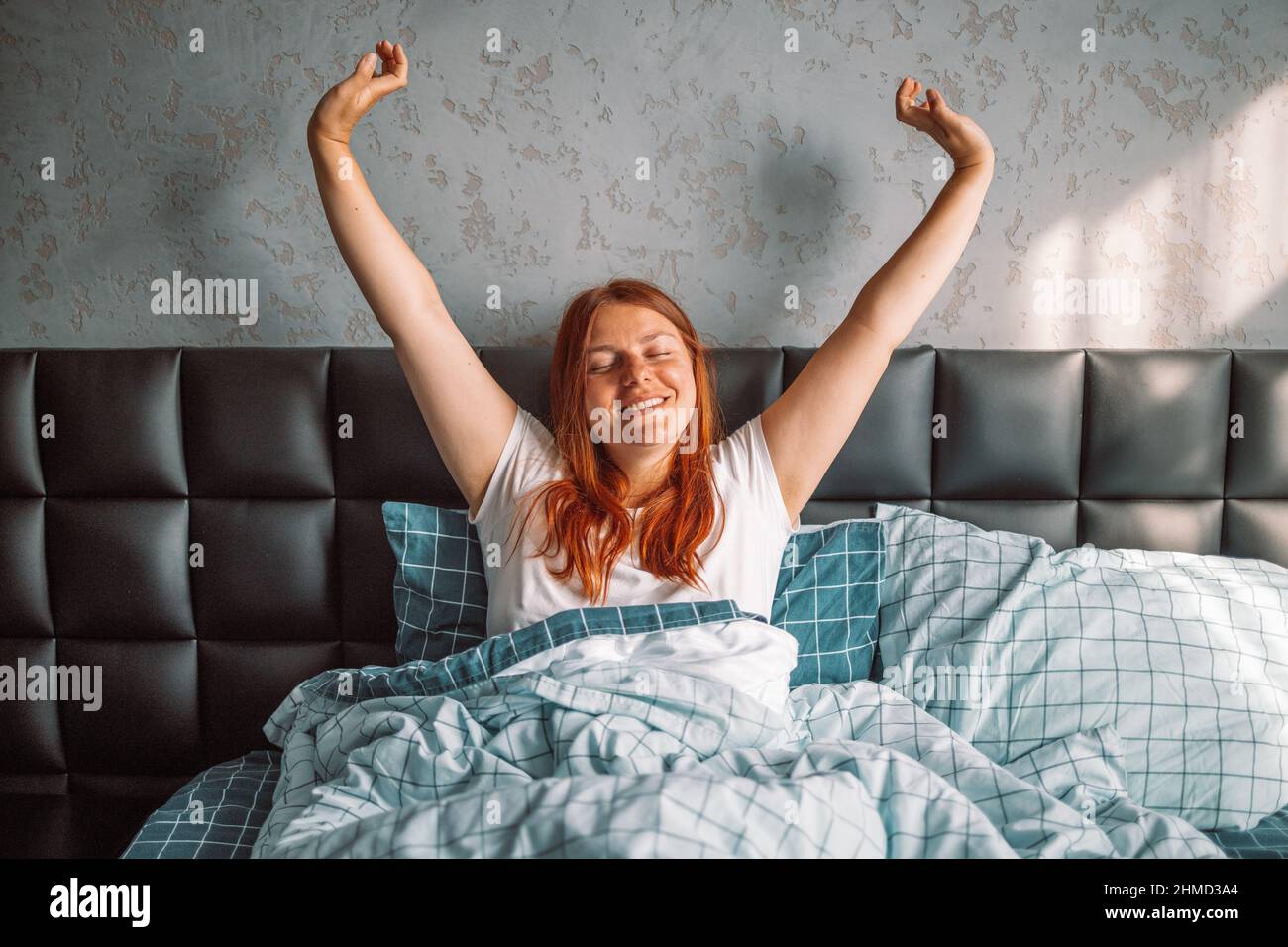 Beautiful young woman stretching in bed after wake up Stock Photo - Alamy