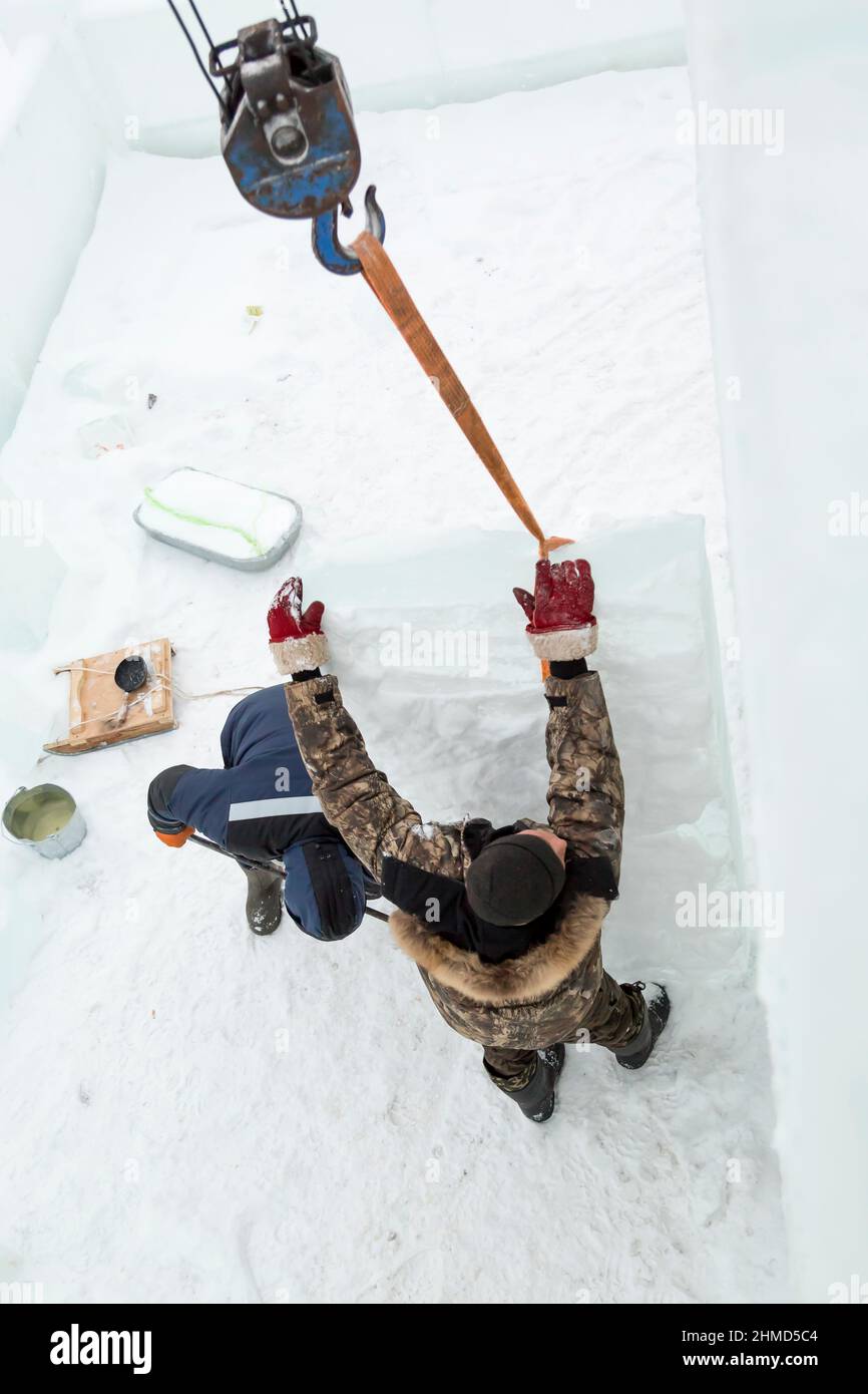 Slingers unload ice slabs with a truck crane Stock Photo - Alamy