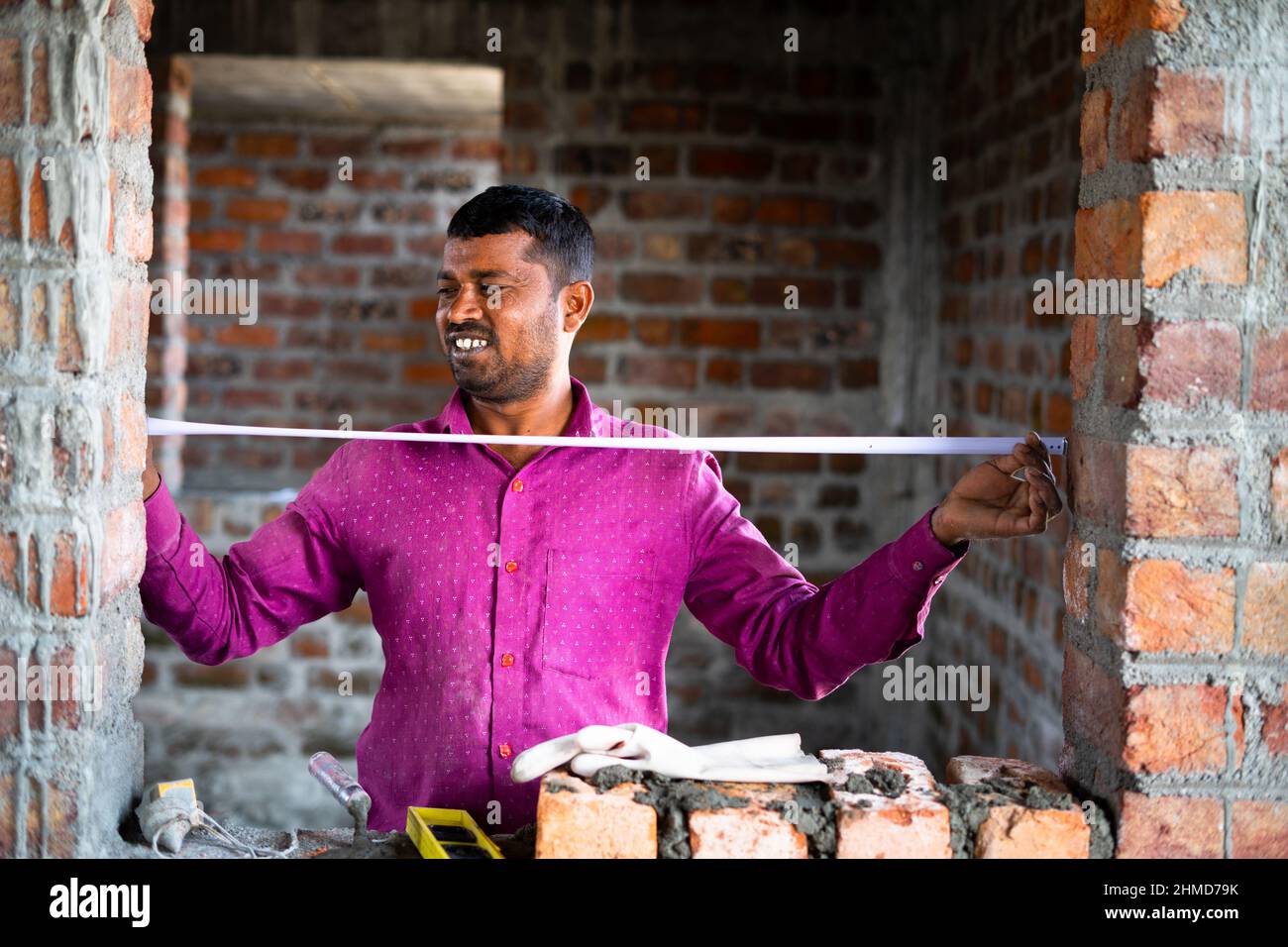 Serious Construction worker busy measring wall distance using tape ...