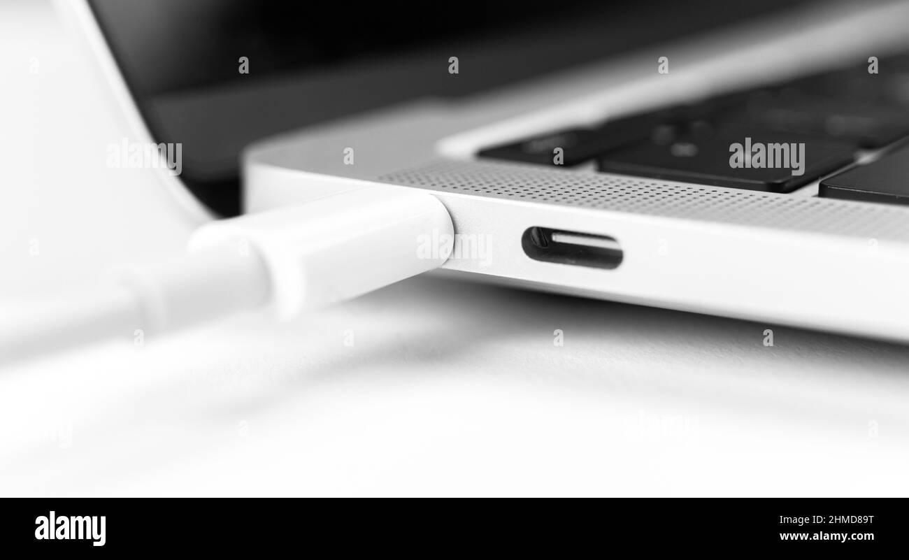 Charging battery laptop. Modern USB C port for fast charge. White cable ...