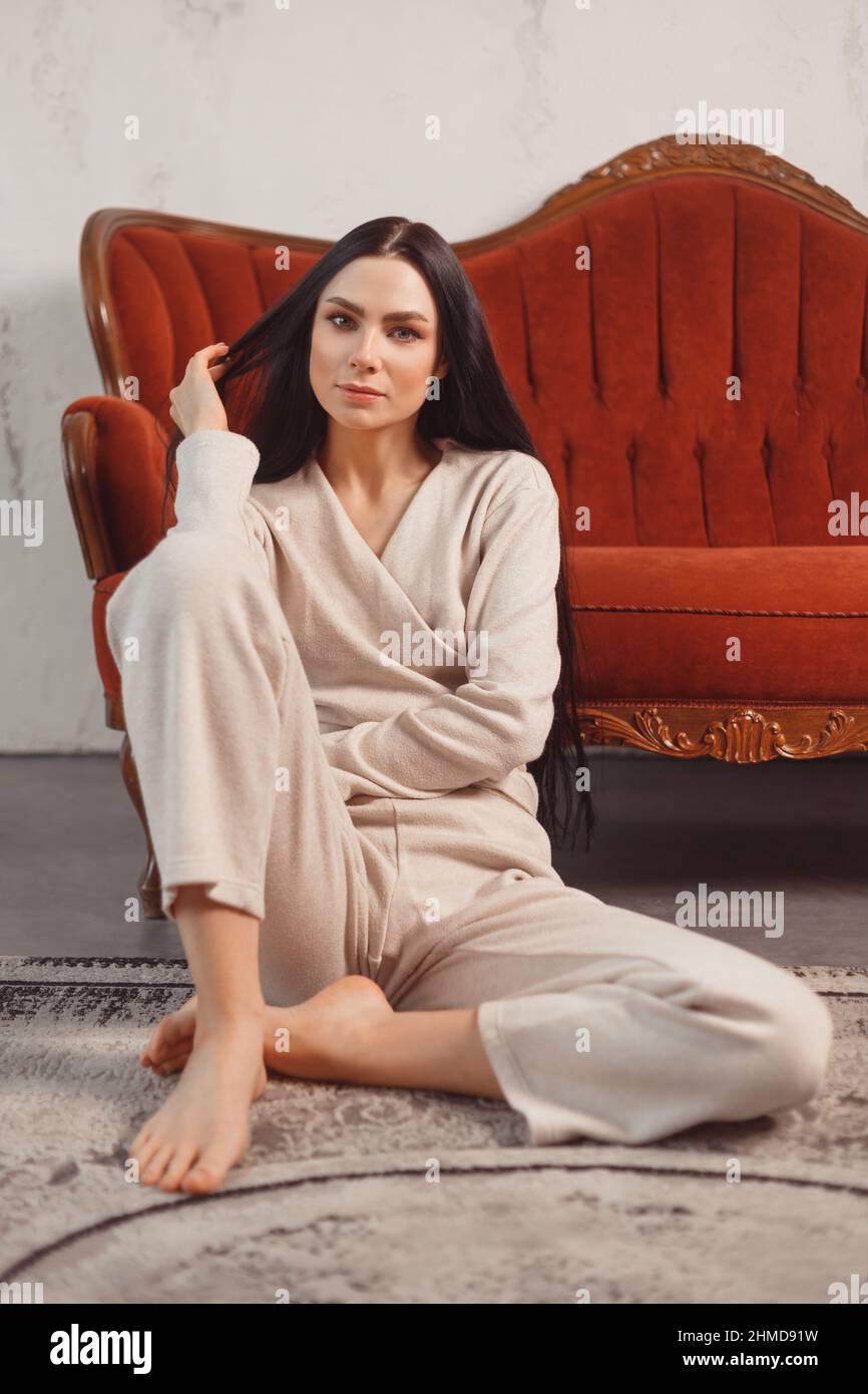 Young brunette barefoot woman in warm cashmere clothes at home. Home ...