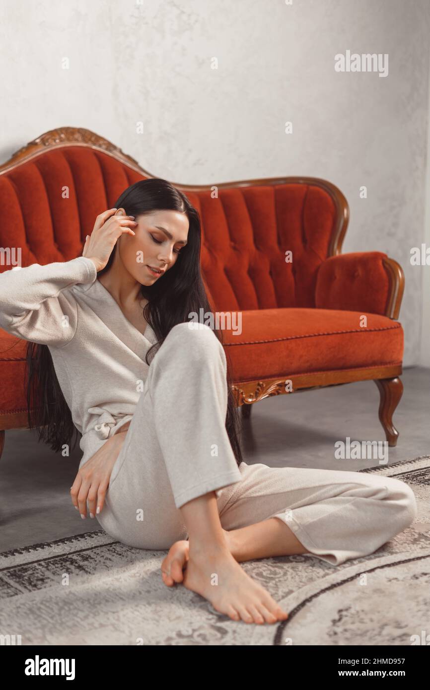 Young brunette barefoot woman in warm cashmere clothes at home. Home ...