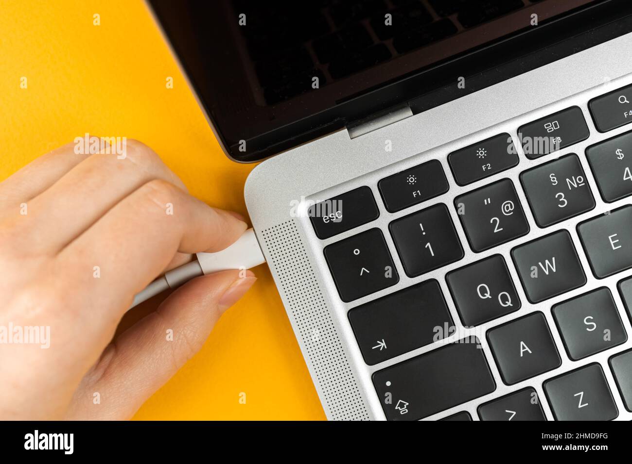 Woman plugging charger in a laptop. Type C charging port. Low battery ...