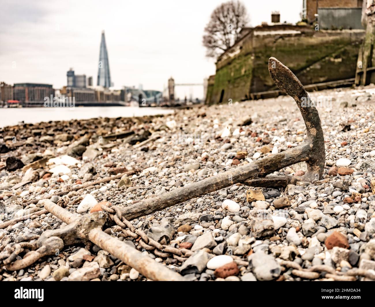Old anchor in the Thames shale, with Tower Bridge and the Shard Stock ...