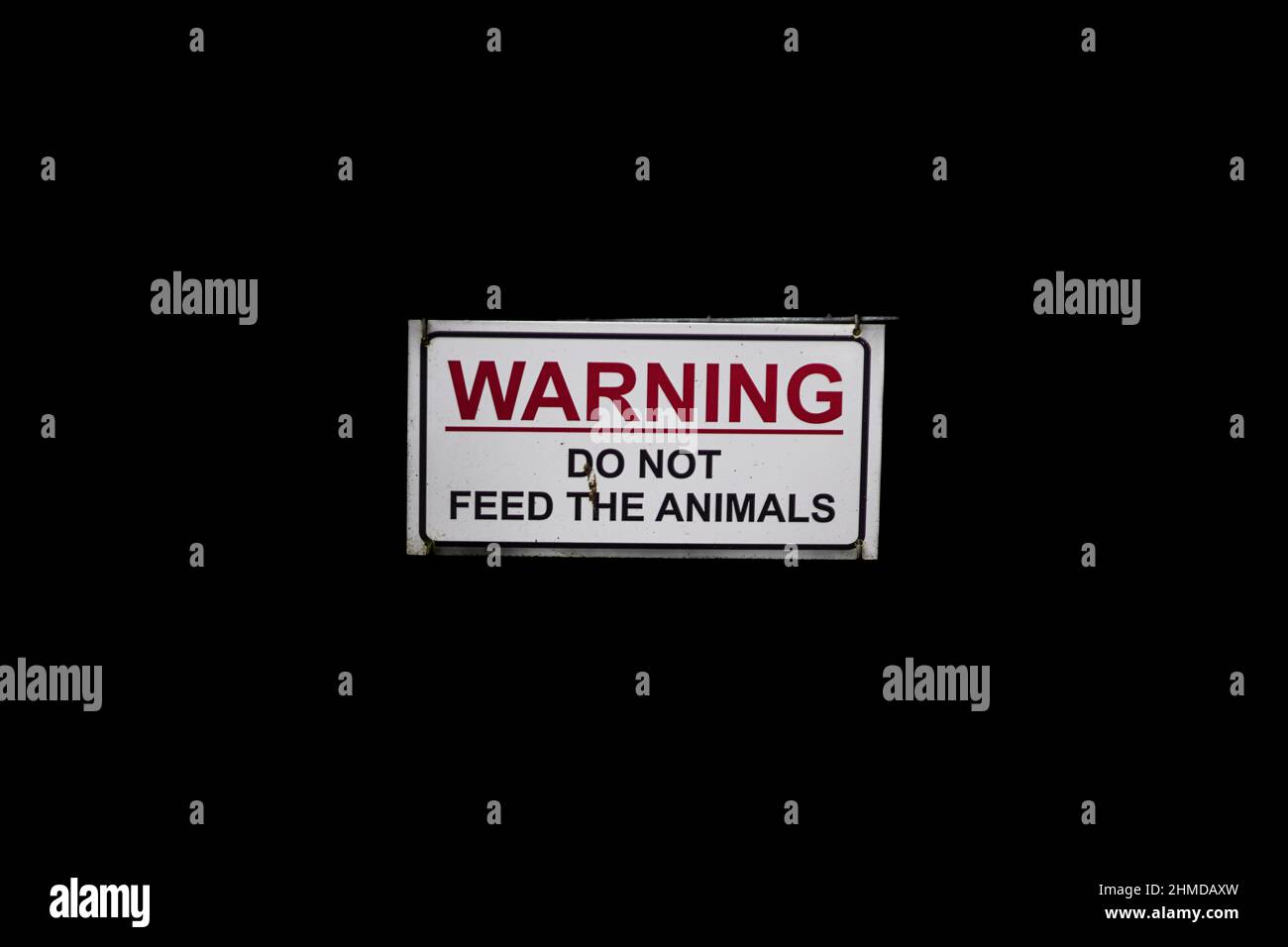 Warning, Do not feed the animals sign set on a black background ...