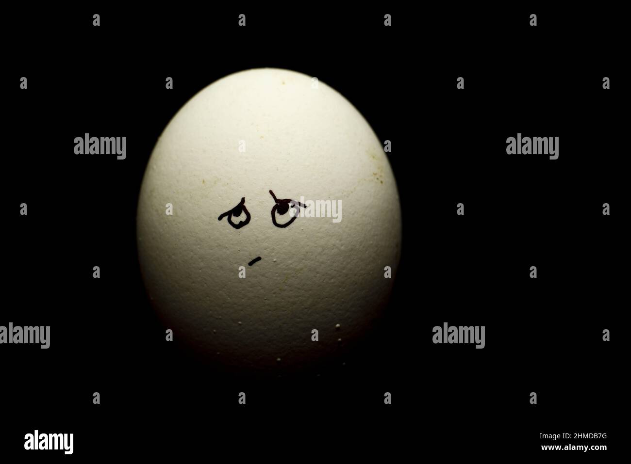 Egg represent angry human face isolated against black background Stock ...