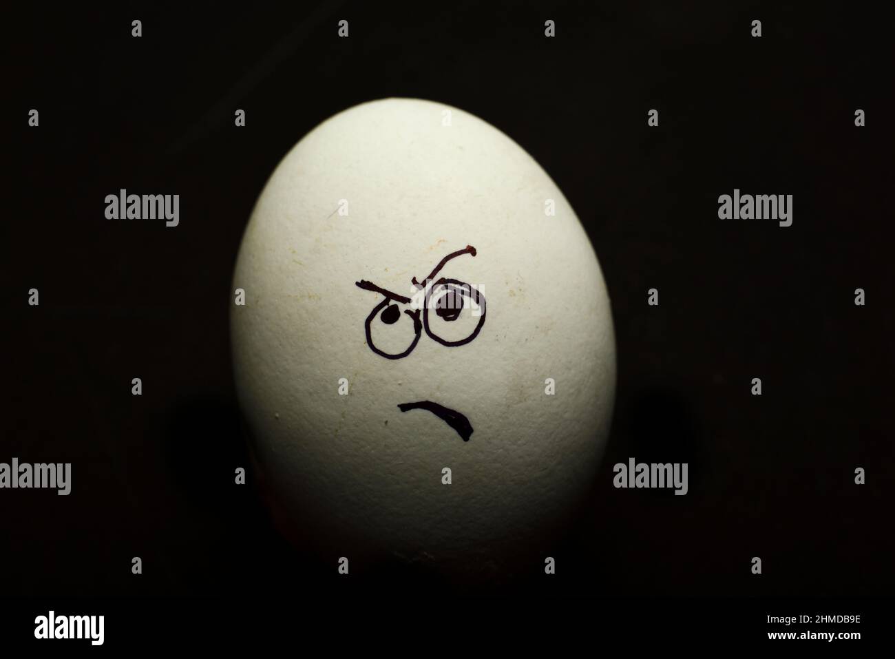 Egg represent energy human face isolated against black background Stock ...
