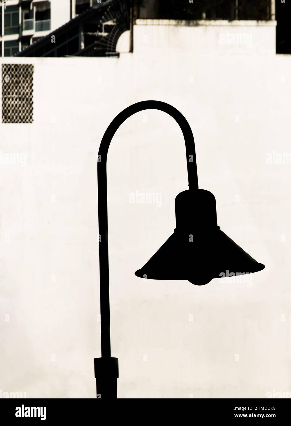 Shadow of Street lamp and a steel pole on surface white concrete wall ...