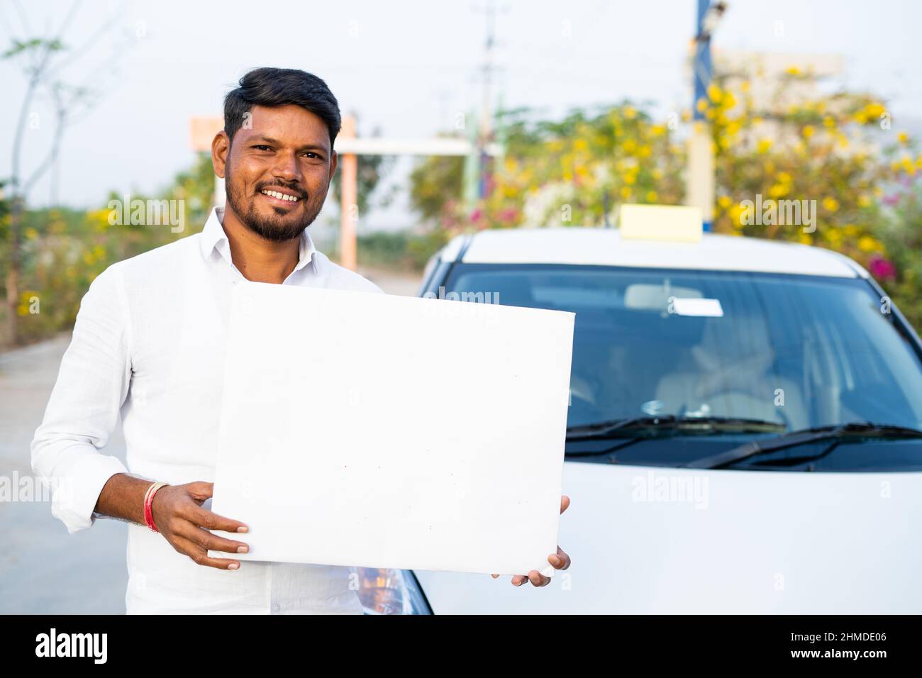 Happy smiling cab driver with empty white board or placard standing in ...