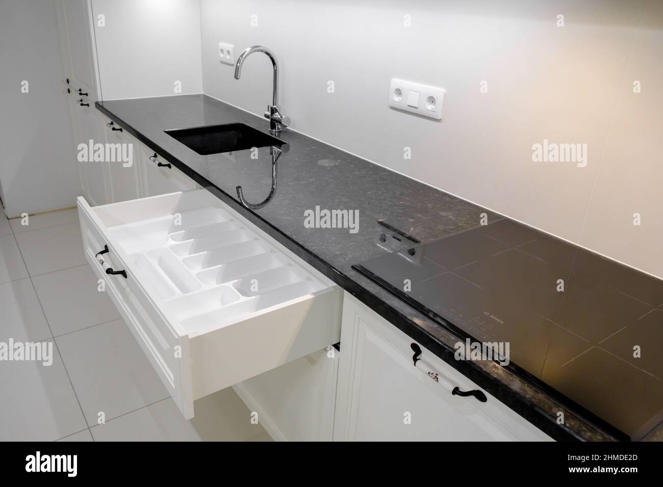 Side view modern and elegant kitchen with white drawers and cupboards ...