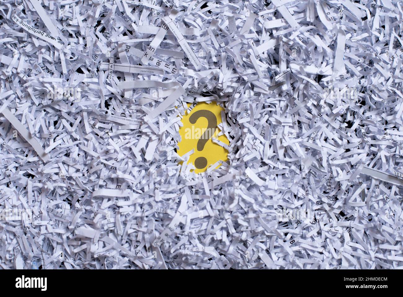 white shredded paper revealing a question mark. Concept of questions ...
