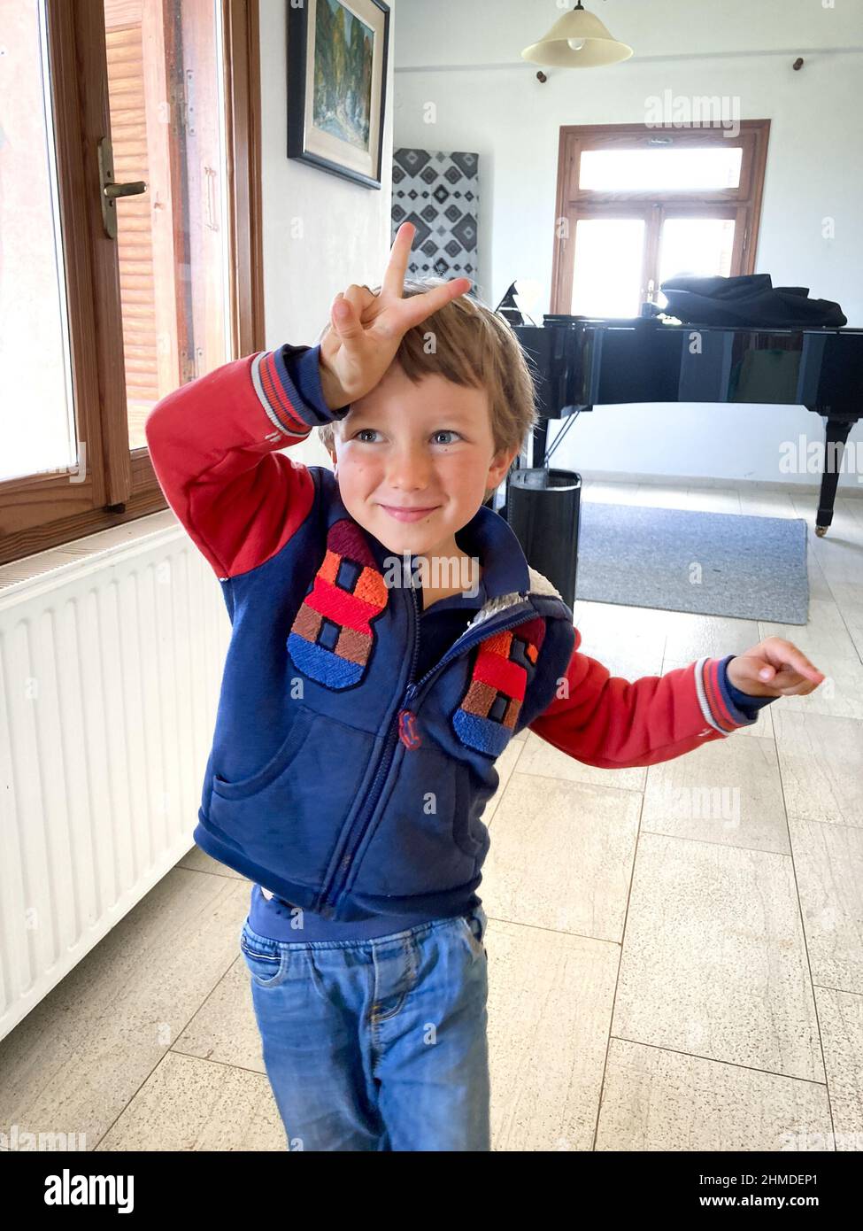 Cute little boy showing peace sign with fingers at home Stock Photo - Alamy