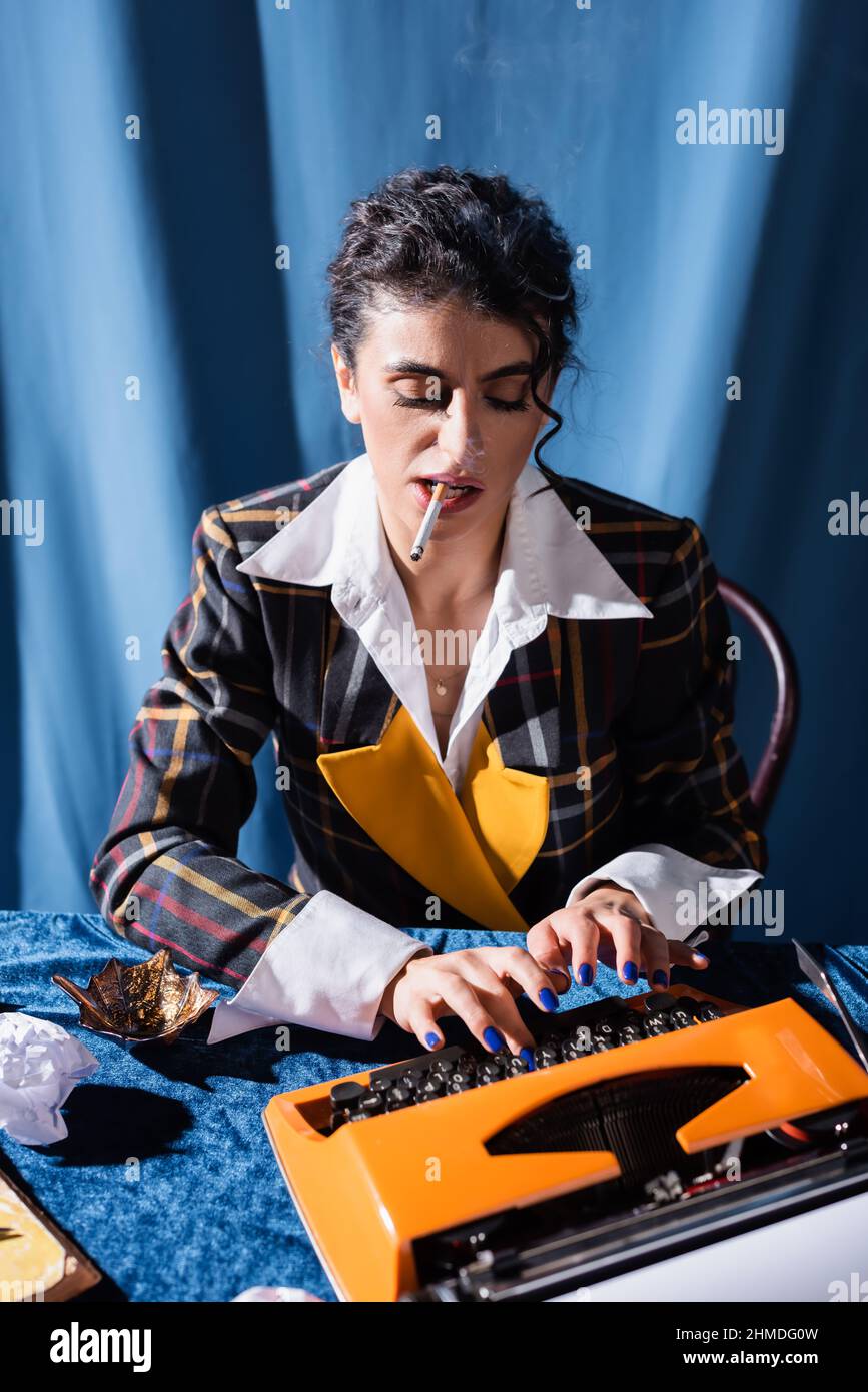 retro style newswoman with cigarette in teeth typing on typewriter on ...