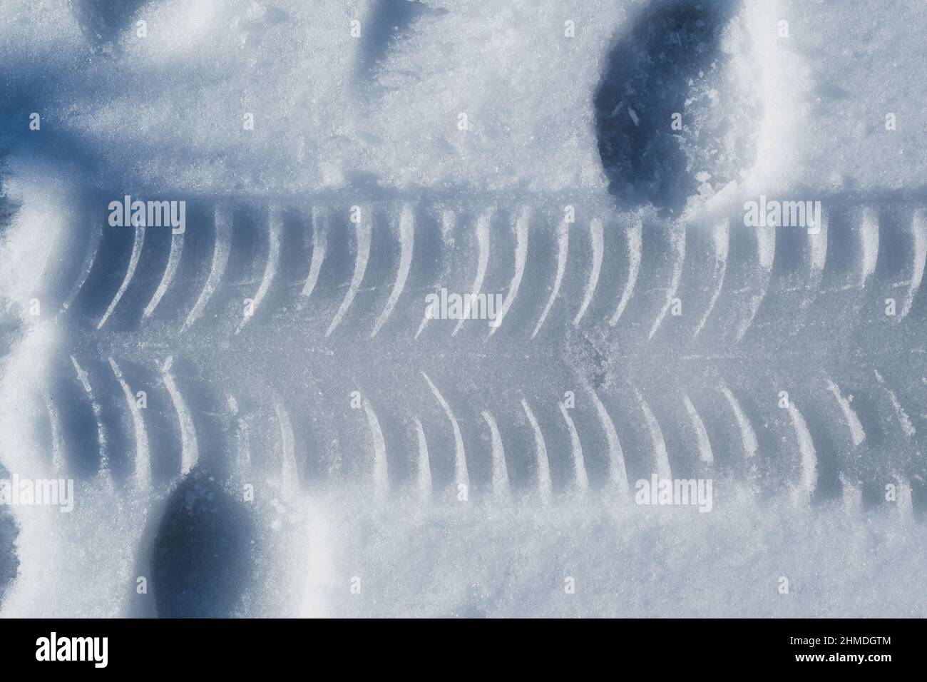Tire track and some footprints on snow in winter season Stock Photo - Alamy