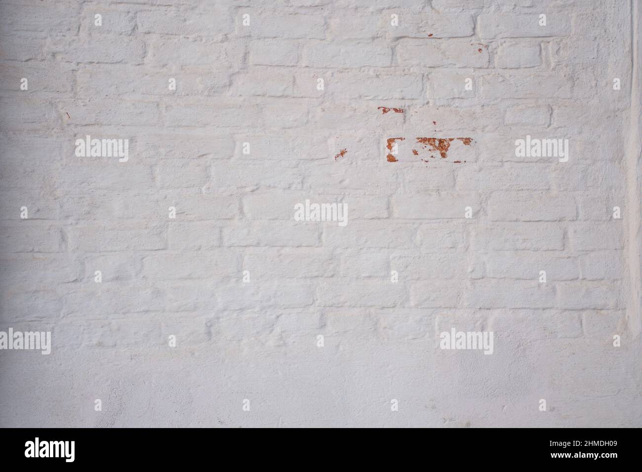 Stories of the old church. White painted church brick wall with damaged ...