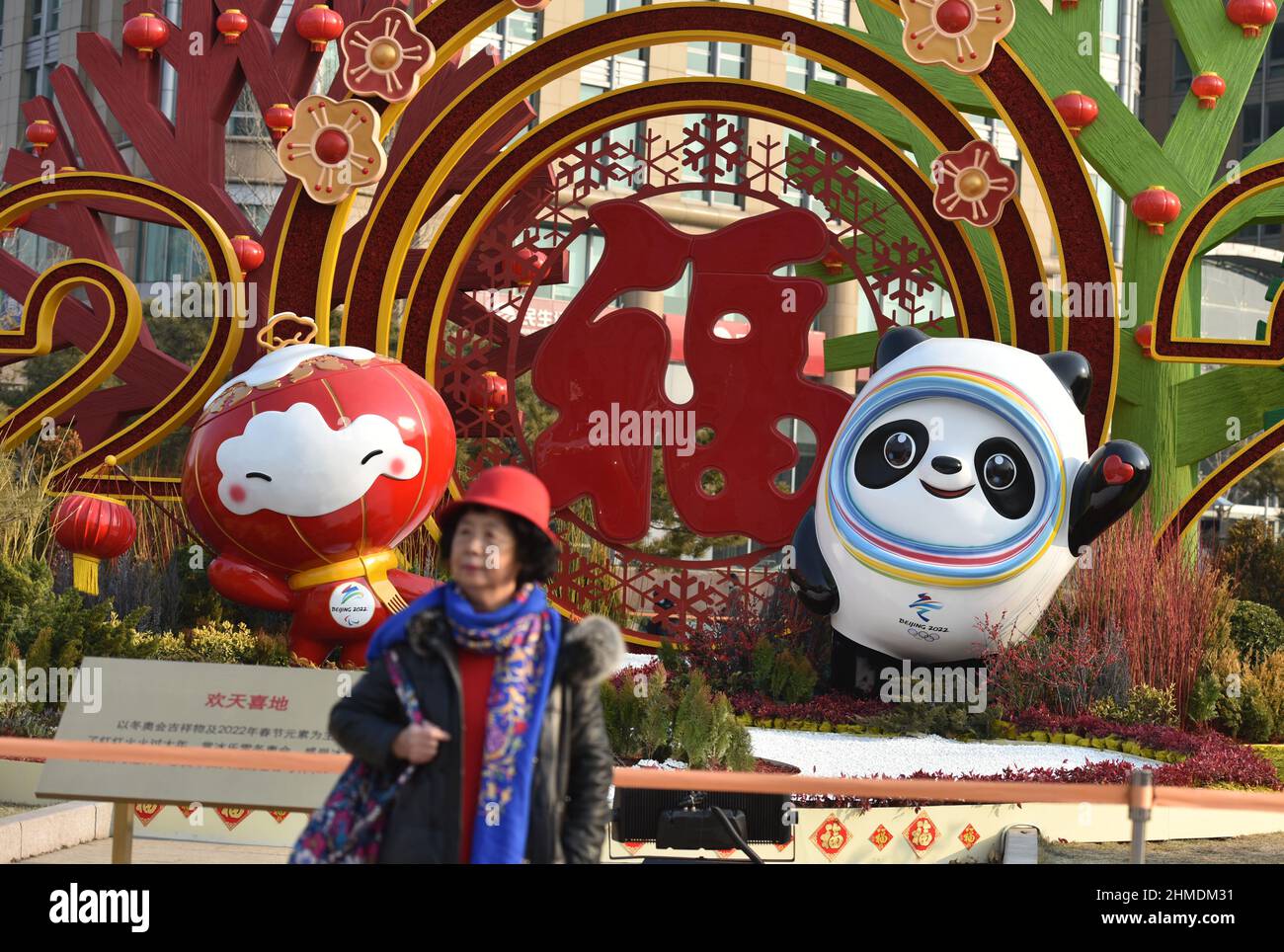 A tourist poses for a photo with the Winter Olympics mascot bing Dwen Dwen and the Winter ...