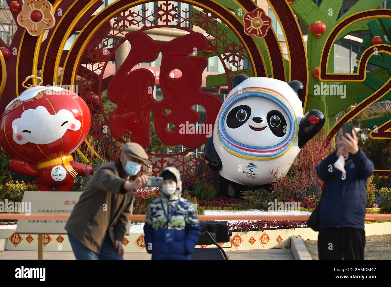 Beijing, China. 09th Feb, 2022. Tourists pose for a photo with the Winter Olympics mascot bing ...