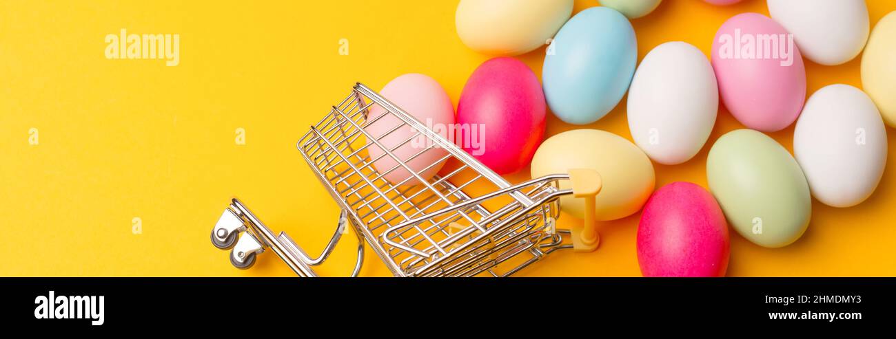 Top view photo of shopping trolley with copyspace over yellow ...
