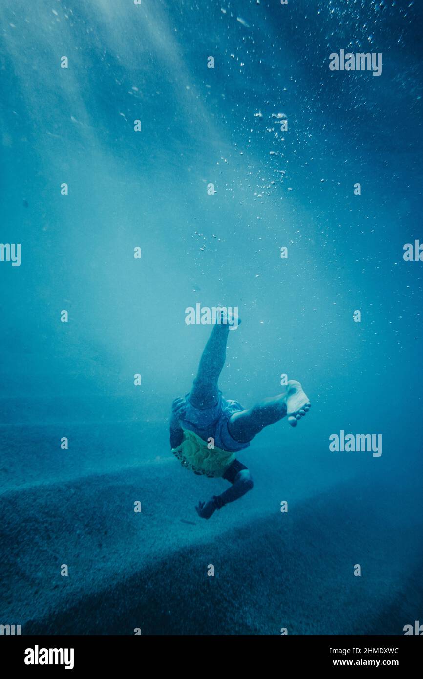 Person swimming underwater in clear blue sea Stock Photo - Alamy
