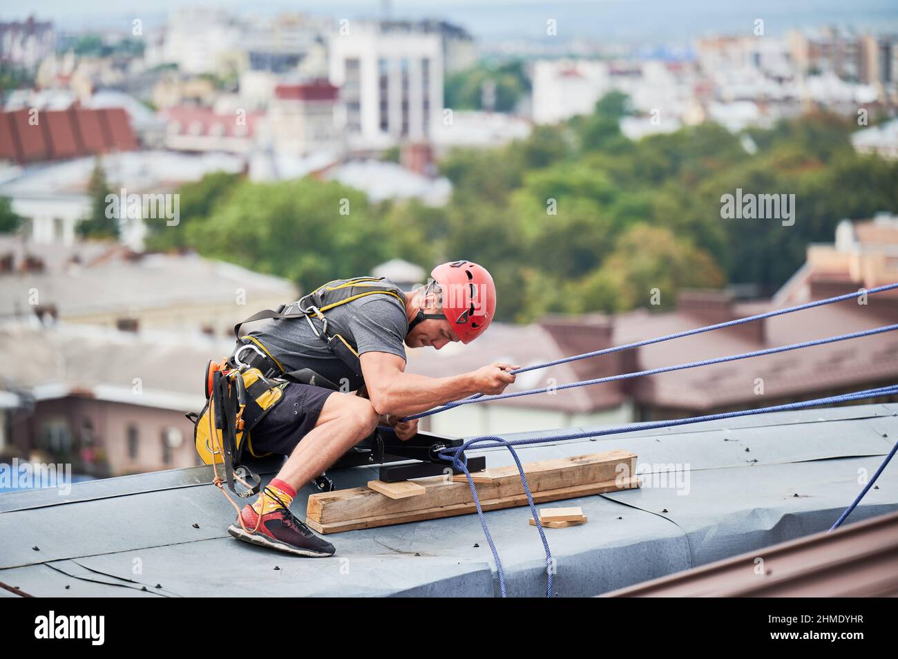 Industrial mountaineering worker in protective helmet using safety ...