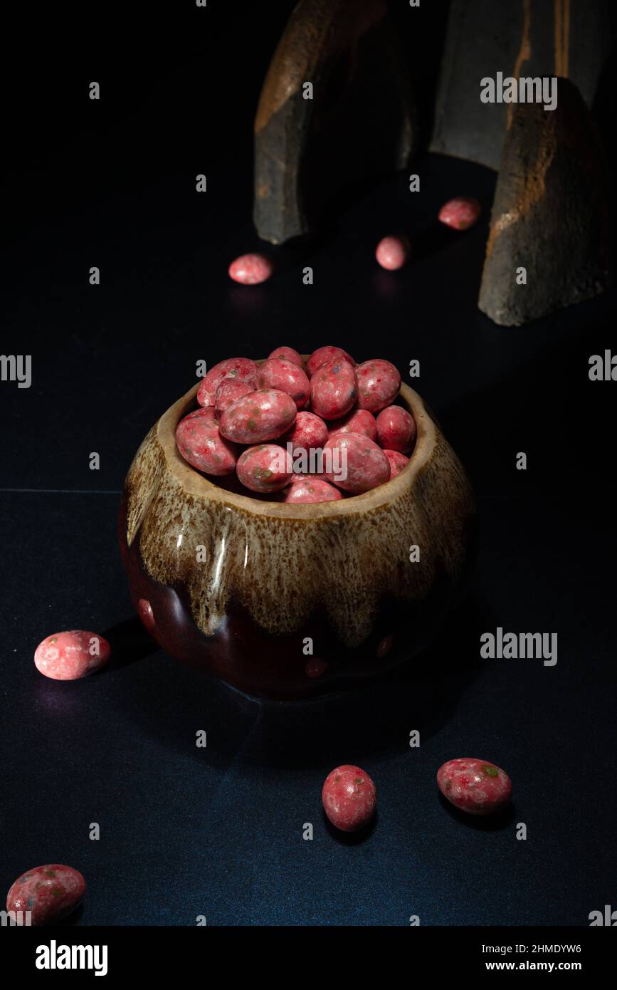Chocolate dragees in crispy colored glaze. Dragee with almonds in a ...