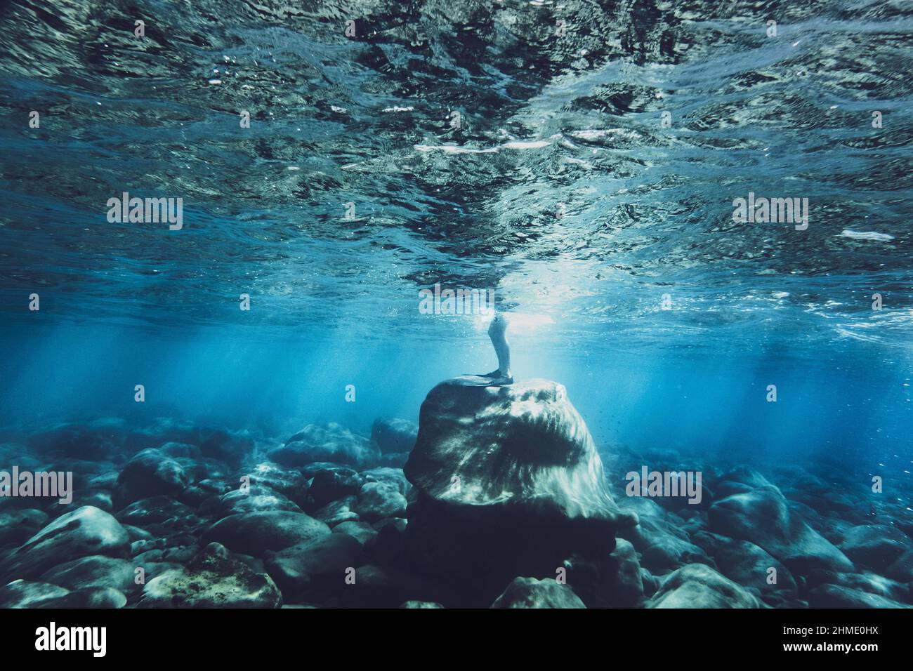 Underwater shot of person standing on rock in clear water sea Stock ...