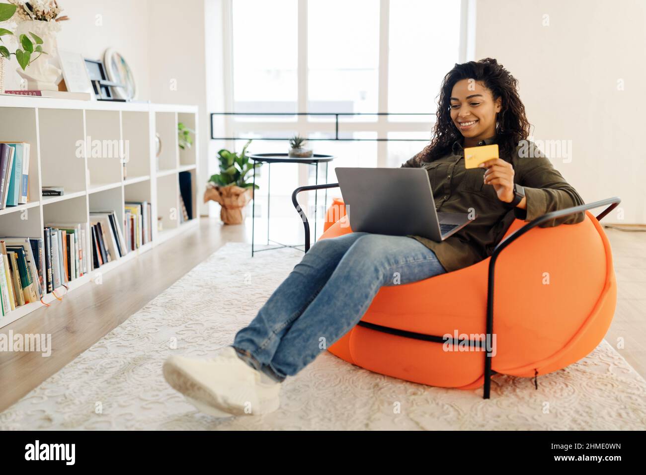 Happy woman holding debit credit card, using pc Stock Photo - Alamy