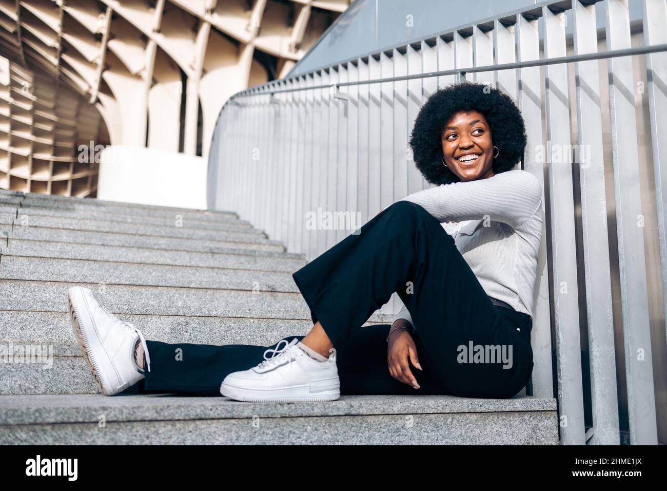 Beautiful smiling black teenage girl sitting on steps in the street ...
