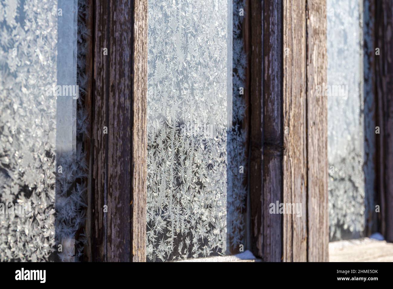 Melting ice running down a window pane, Closeup of frozen window pane ...