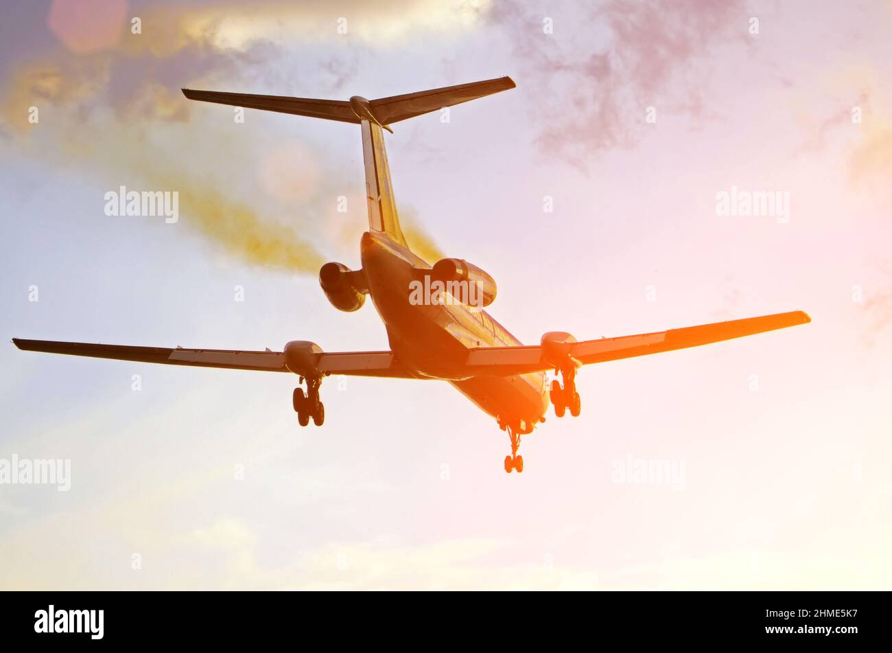 Aircraft landing with smoke from the engines at sunset Stock Photo - Alamy