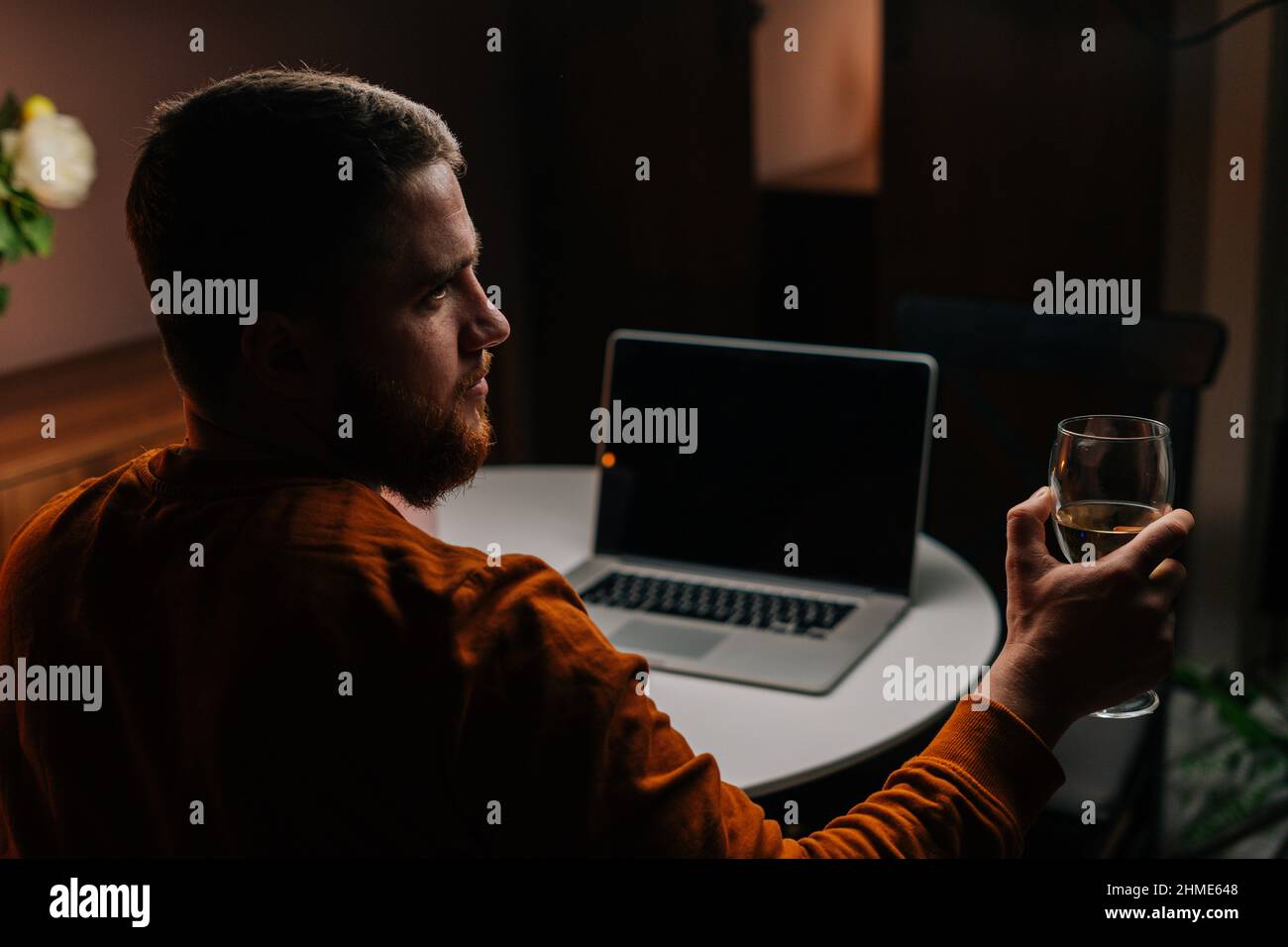 Back view of handsome young man drinking alcohol from glass during ...