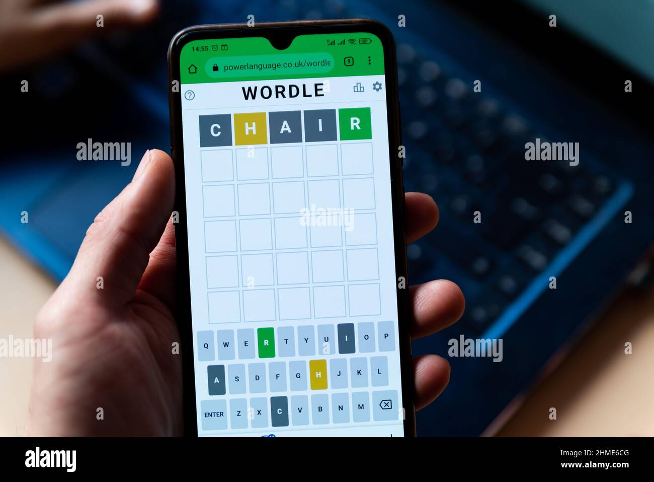 A man plays with the word game Wordle seen in a close up on a mobile ...