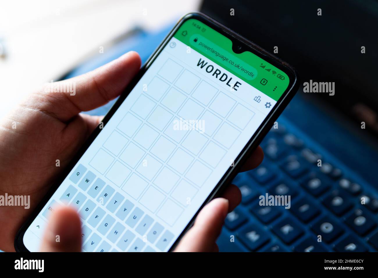 A man plays with the word game Wordle seen in a close up on a mobile ...
