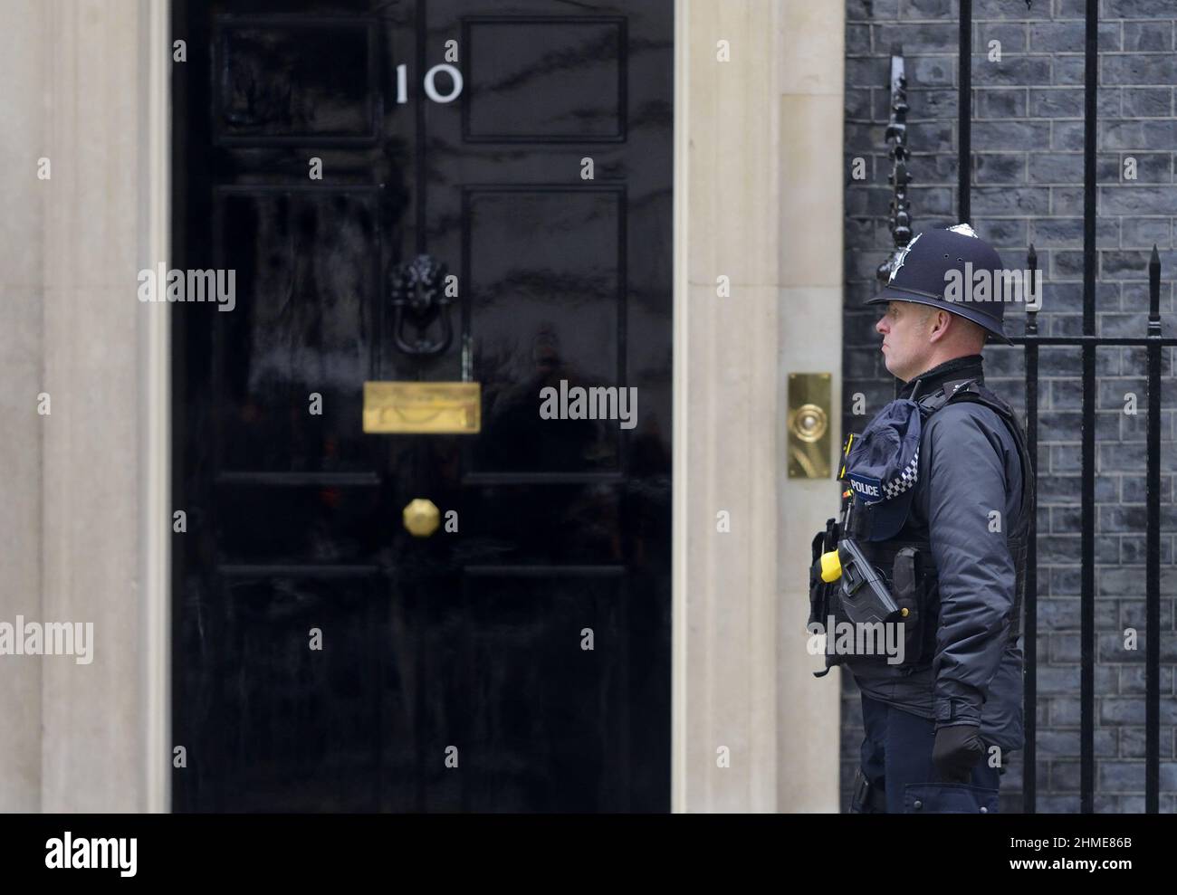 London, England, UK. Police officer passing the door of 10 Downing ...