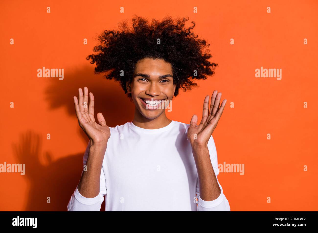 Photo of funny excited guy wear white shirt rising arms smiling ...