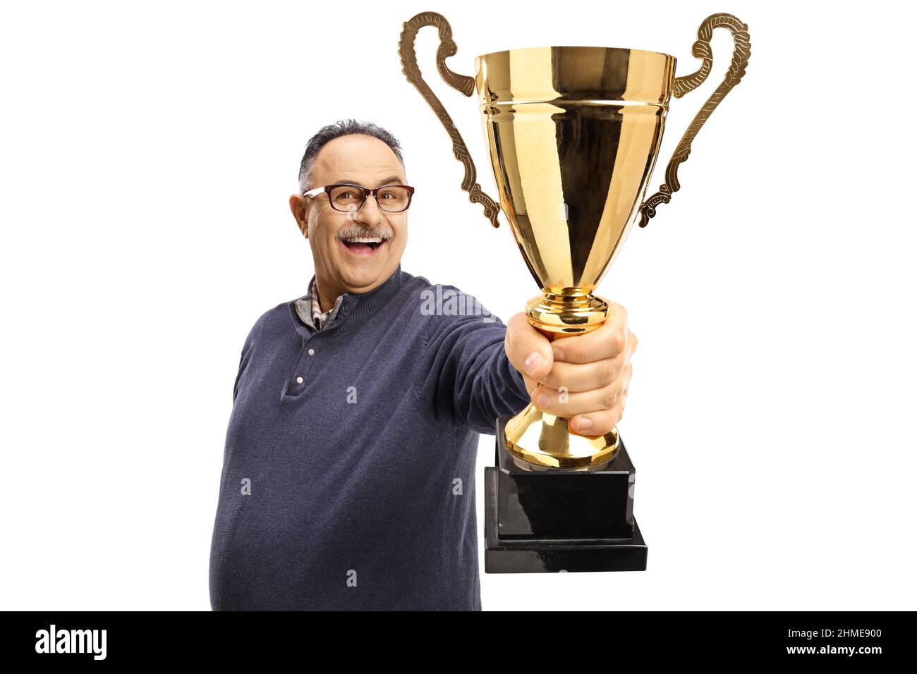 Happy mature man holding a gold trophy cup in front of camera isolated ...