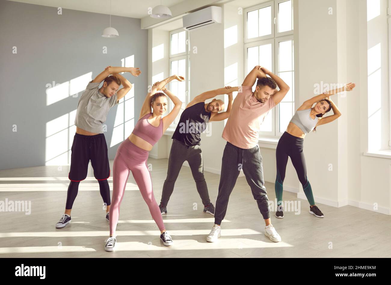 Group of young people doing exercise during a fitness workout with a ...
