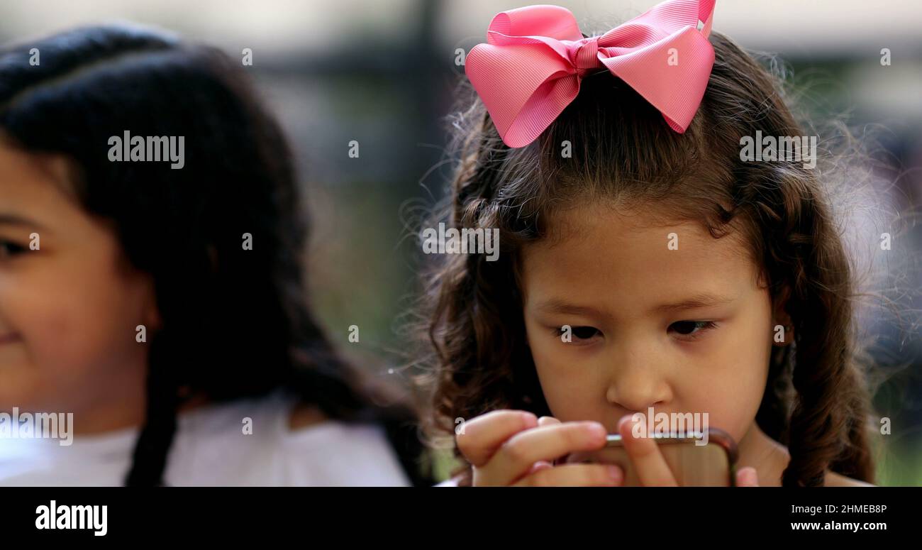 Candid pre-teen girls using smartphone device outdoors Stock Photo - Alamy