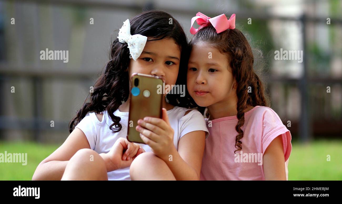 Children excited by notification on cellphone, two little girls kids on ...