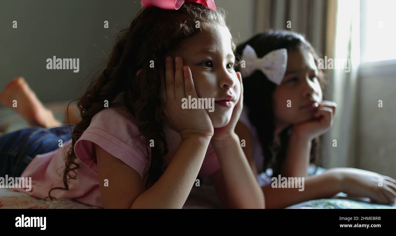 Children lied in bed watching television screen. kid looking at media ...